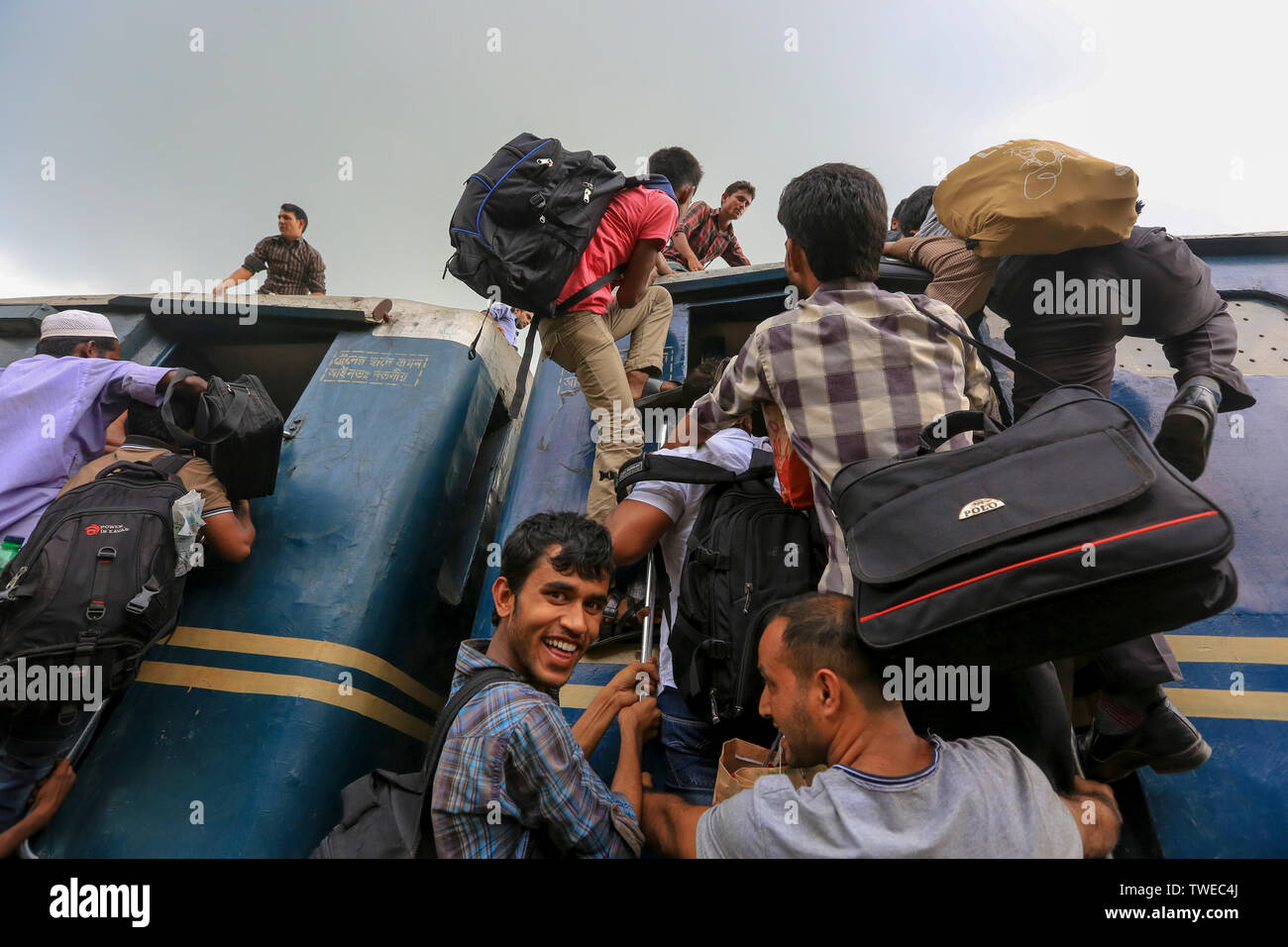 Home-bound people struggle to get the rooftop of a train at Airport ...