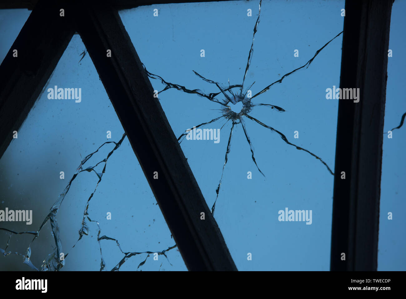 cracked and broken window glass punched by a pistol bullet Stock Photo ...