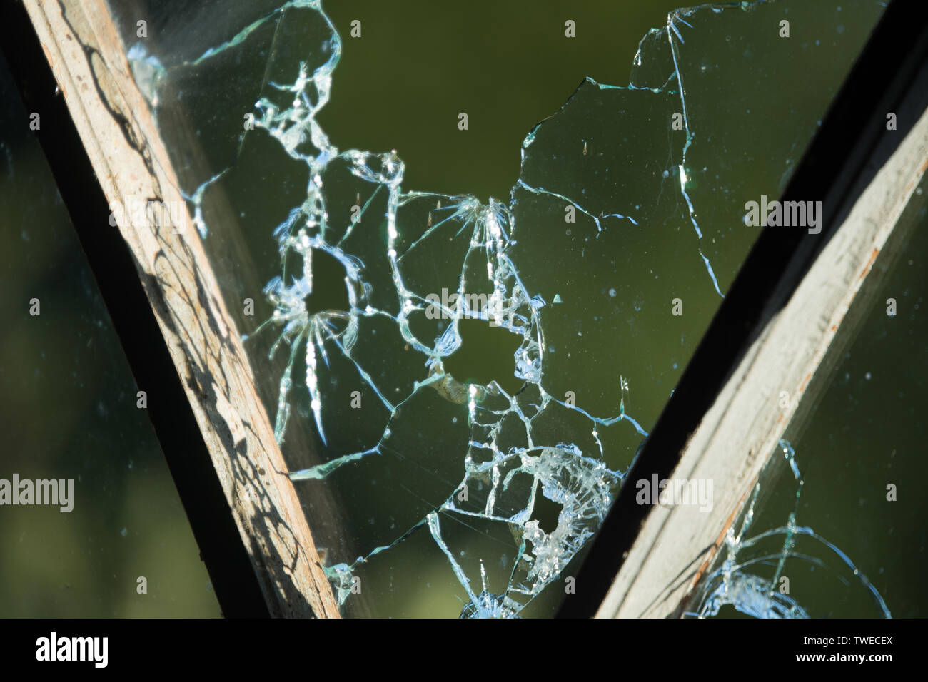 cracked and broken window glass punched by a pistol bullet Stock Photo ...