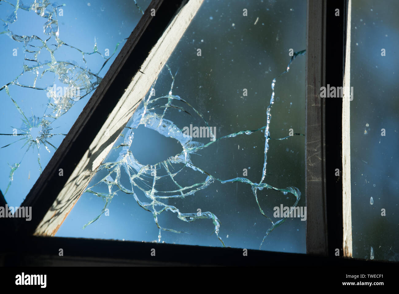 cracked and broken window glass punched by a pistol bullet Stock Photo ...