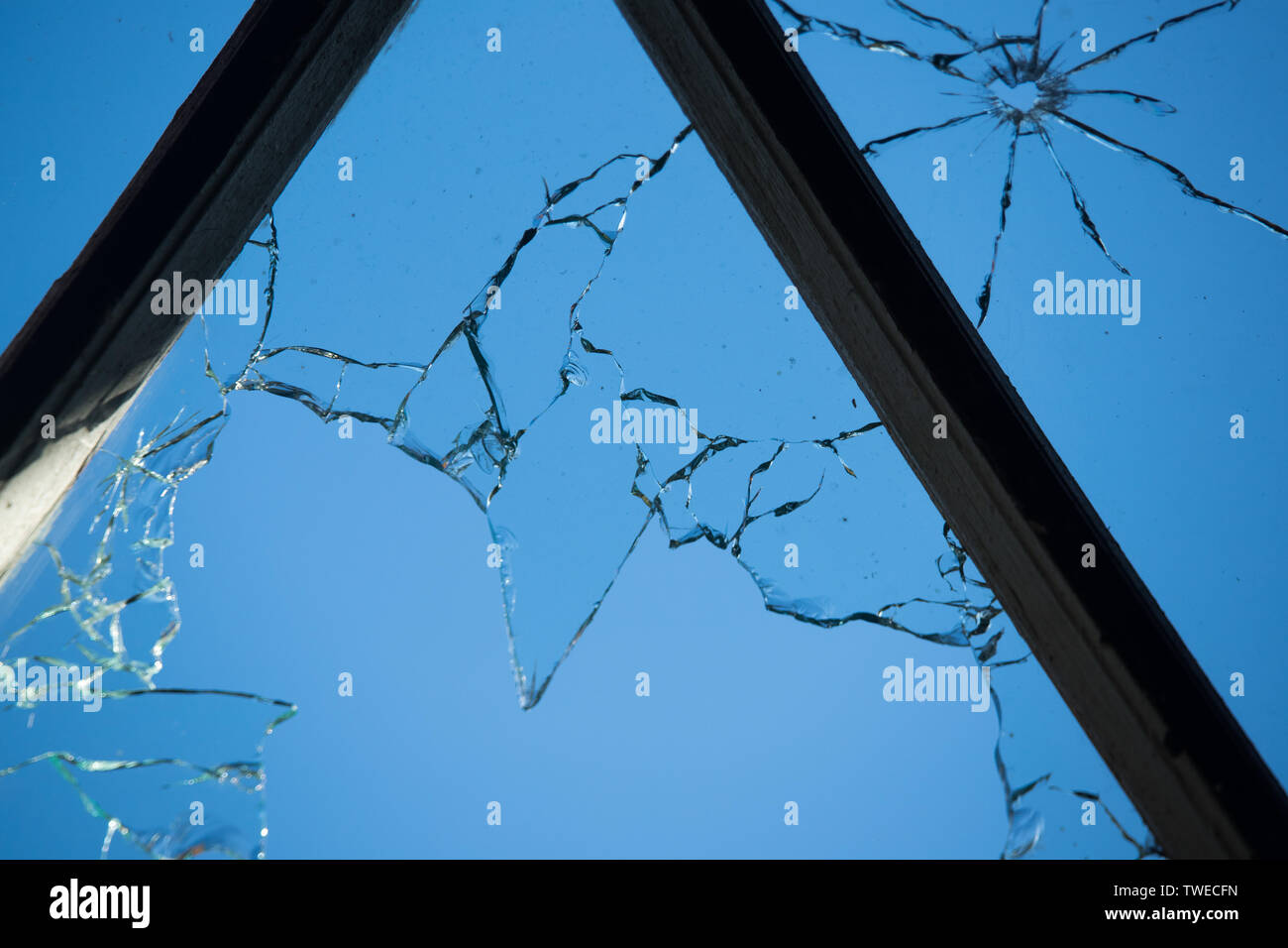 cracked and broken window glass punched by a pistol bullet Stock Photo ...