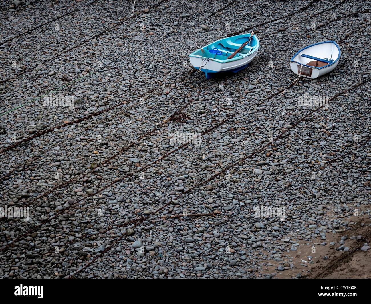Two rowing boats lying on top of chains on a pebble beach Stock Photo ...