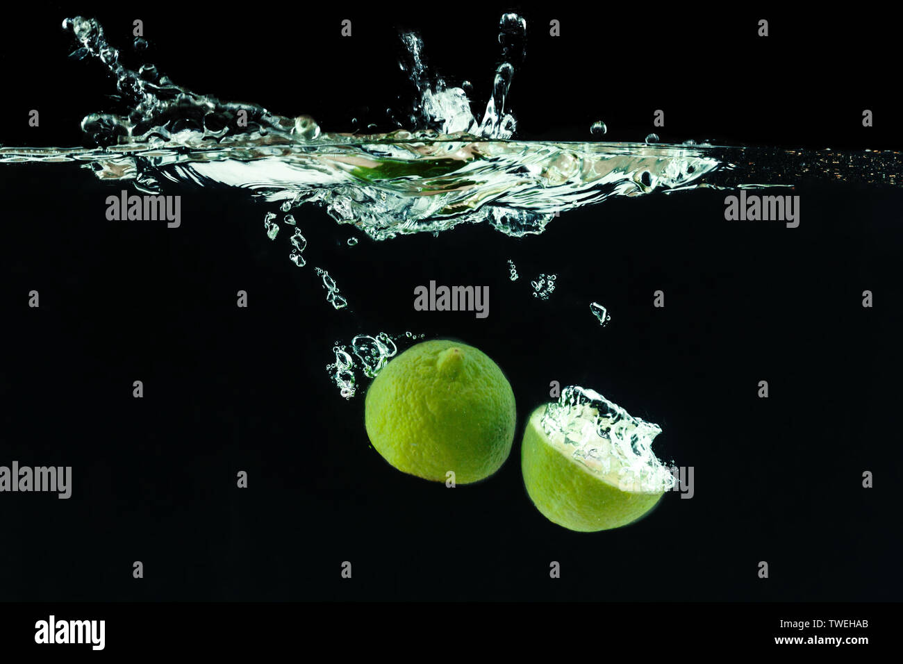 Fresh lime dropped into water with splash Stock Photo - Alamy
