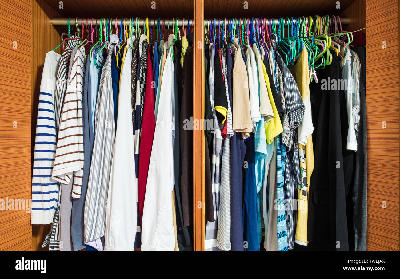 Colorful clothes men hanging in wooden closet Stock Photo - Alamy