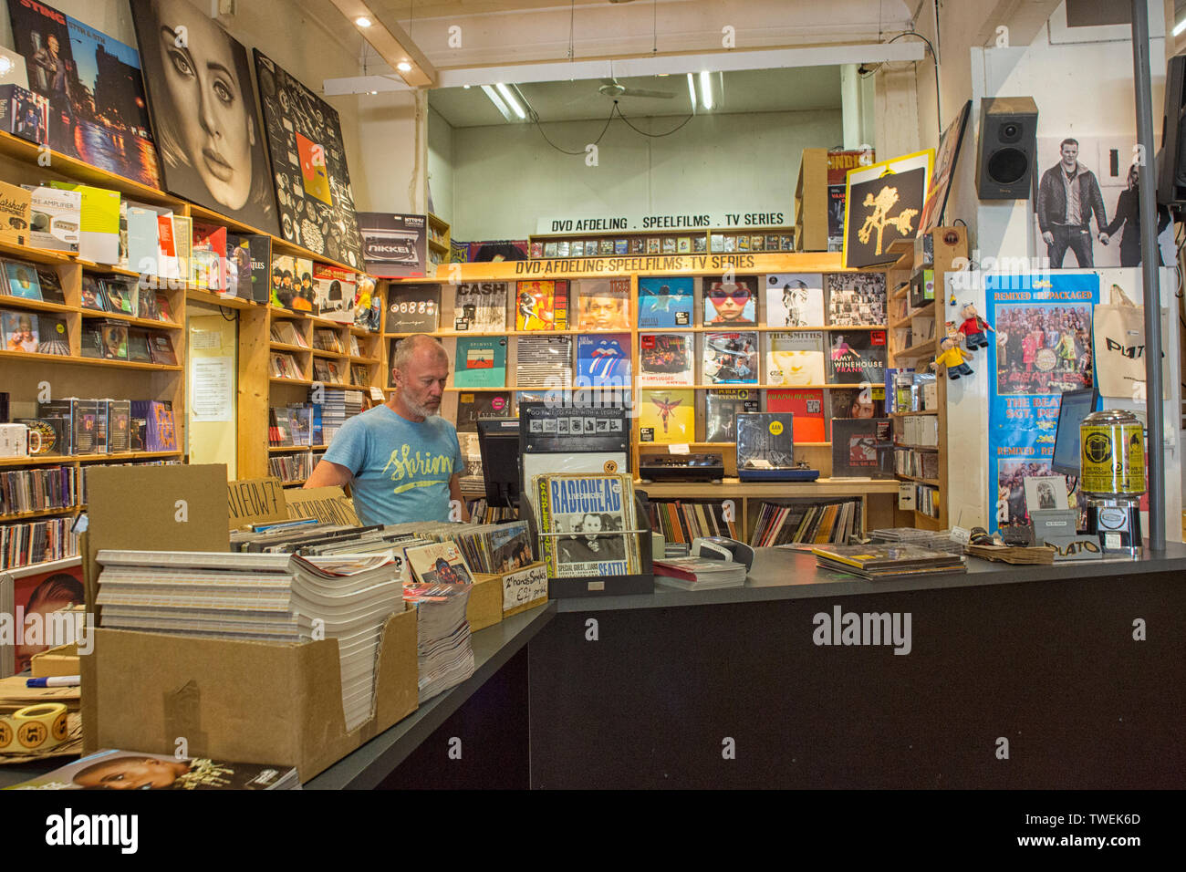 Salesman behind cashier's desk at recordstore Plato in Groningen, The ...