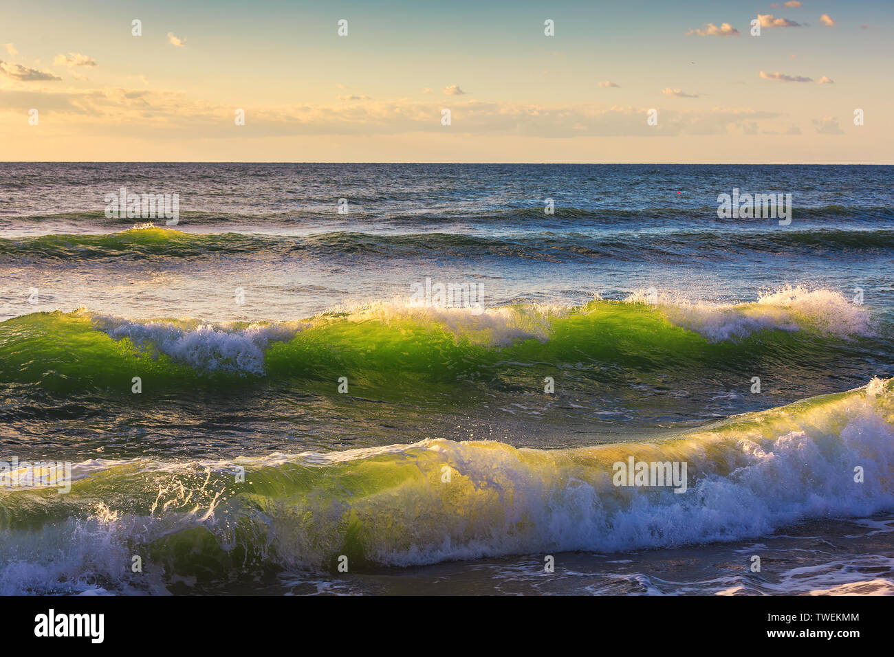Beautiful green sunrise wave and beach Stock Photo - Alamy