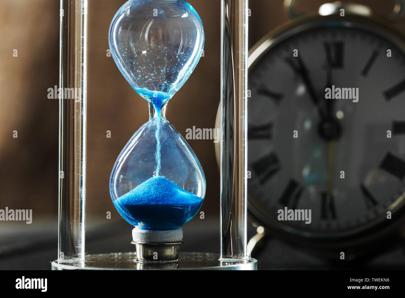 Time is passing. Blue hourglass close up Stock Photo - Alamy