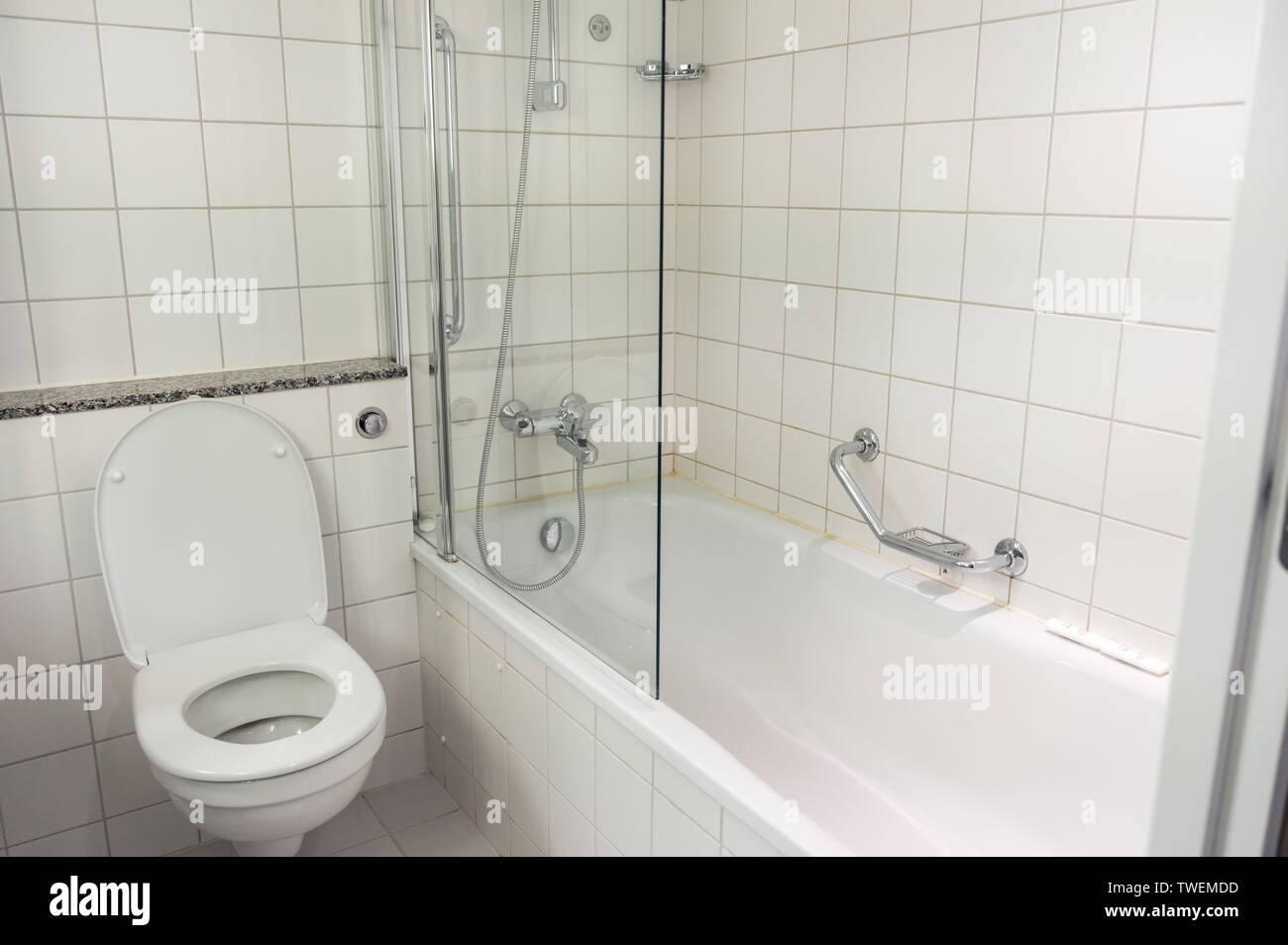 White ceramic clean lavatory with bathtub and glass partition in ...