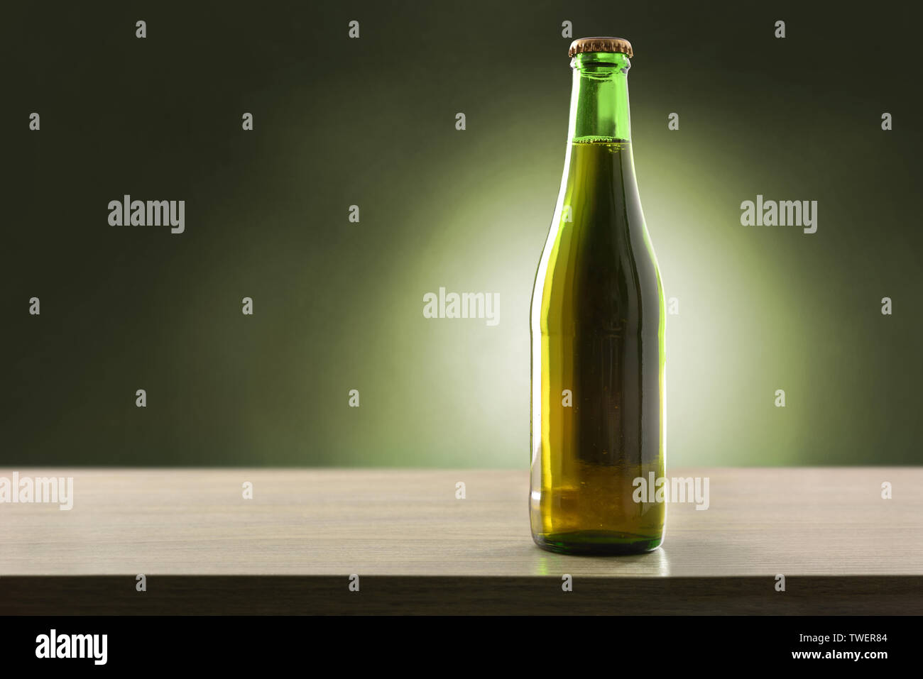 Beer bottle filled and closed on wood table and green background ...