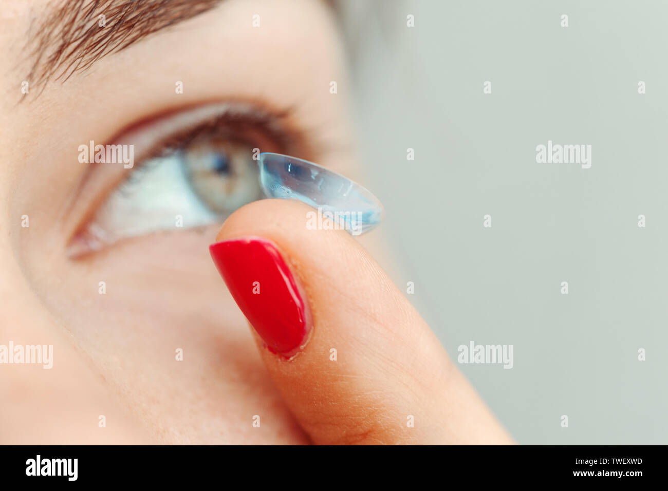 woman putting on contact lenses Stock Photo - Alamy