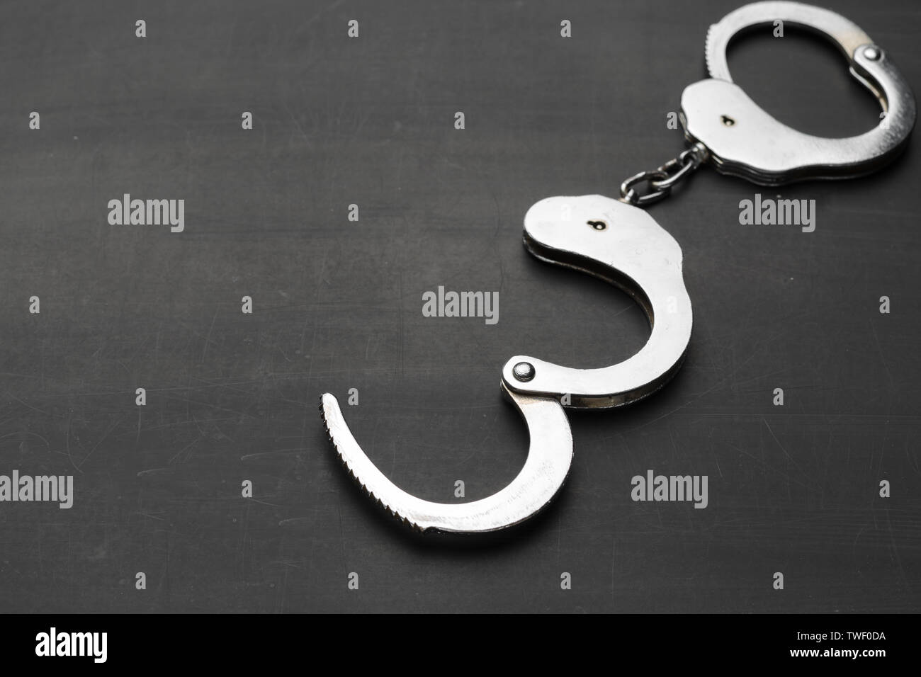 Police handcuffs isolated on black background Stock Photo - Alamy
