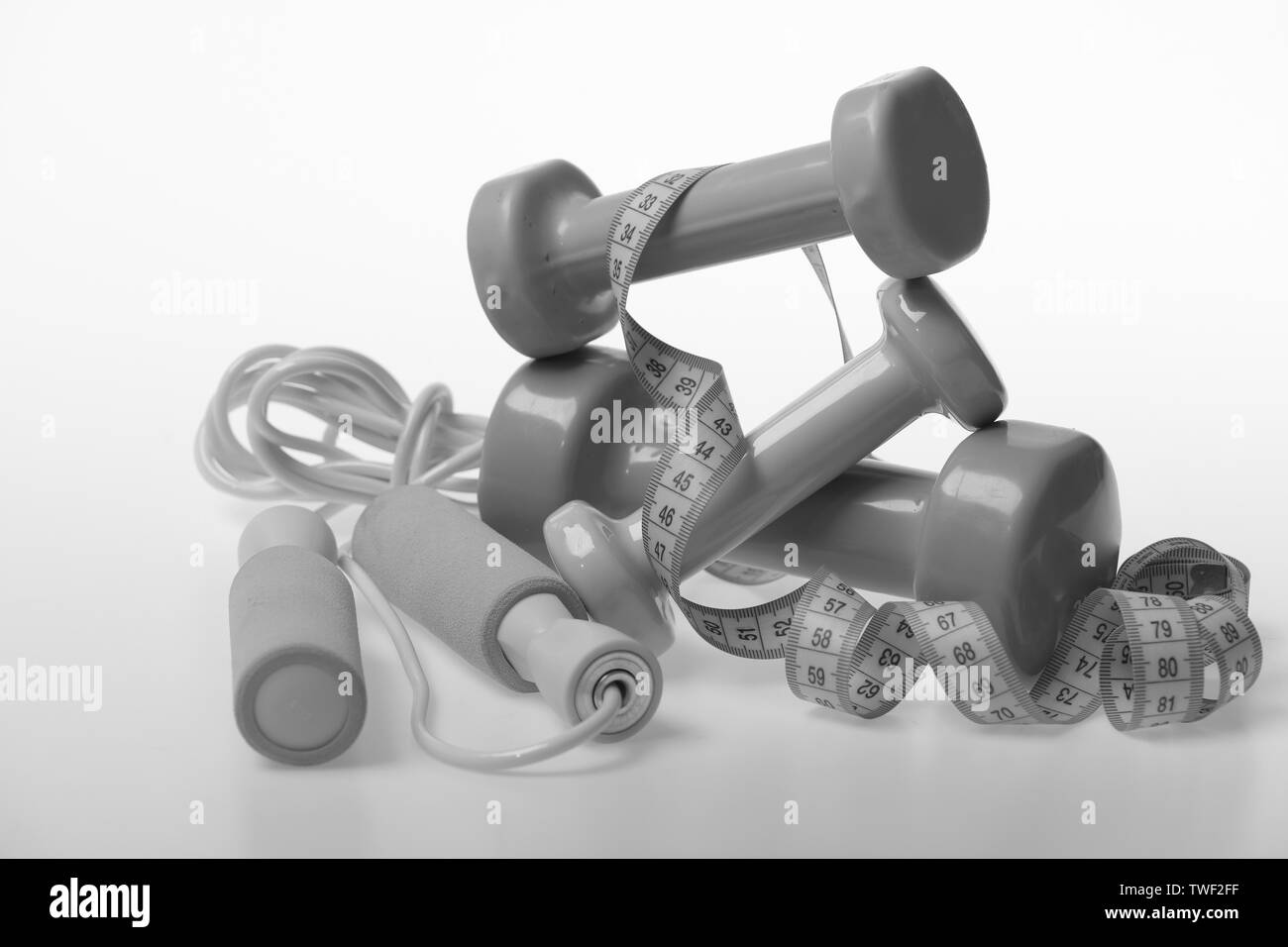 Jump rope, barbells and tape tied around them. Dumbbells and skipping ...