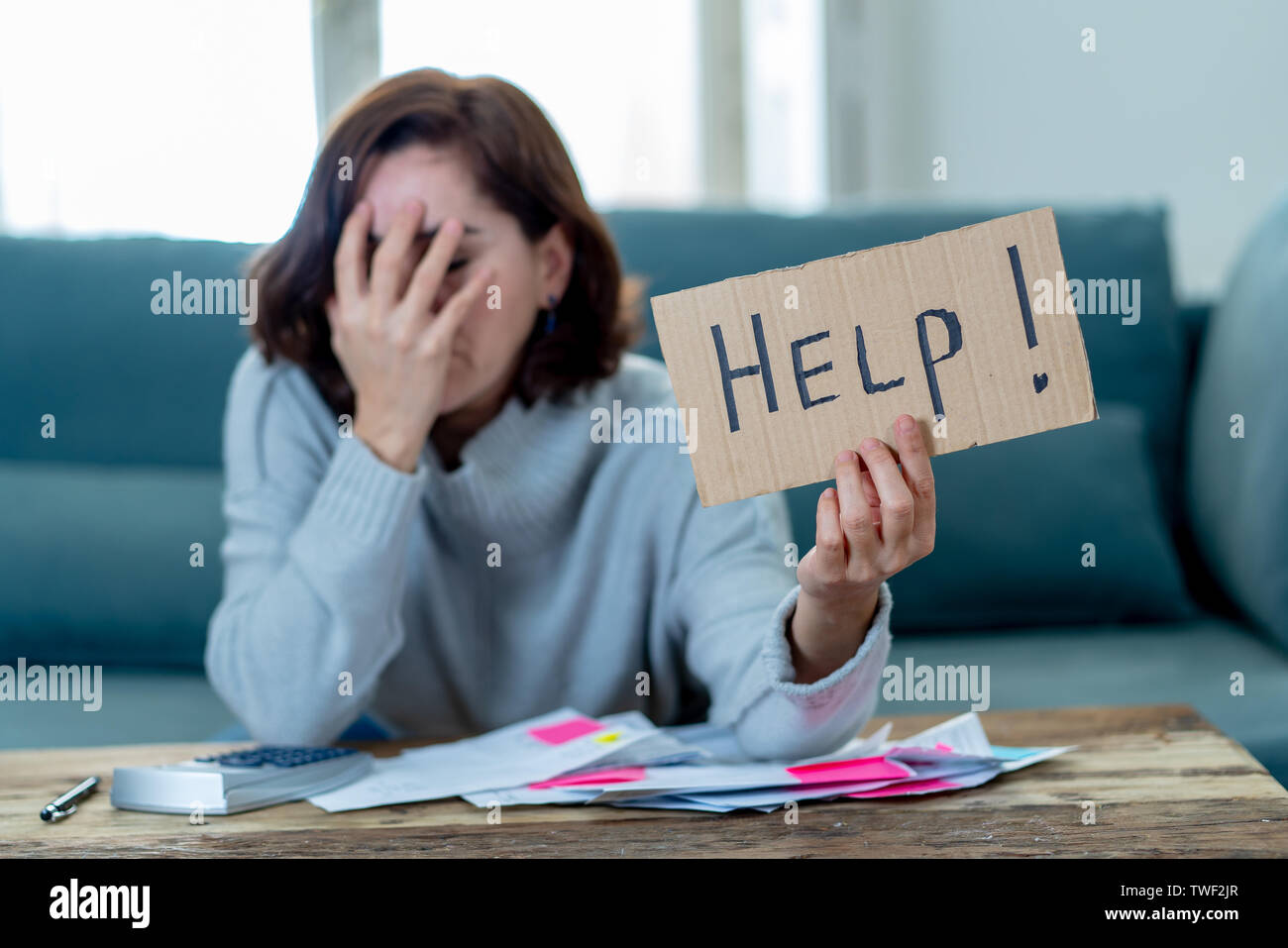 Worried and desperate woman asking for help in paying off debts and ...