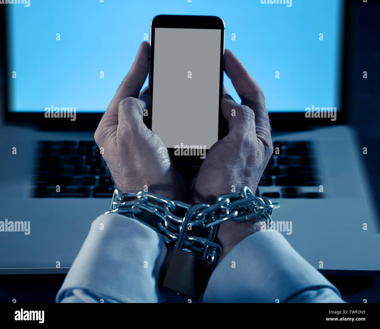 Young man addicted to mobile phone hands bond tied and locked with iron ...