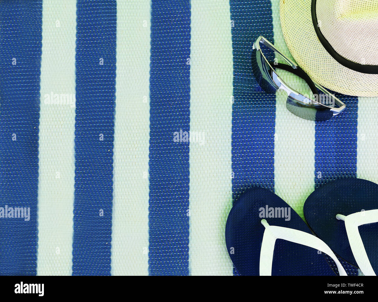 Straw hat sunglasses and slippers on a striped mat Stock Photo - Alamy
