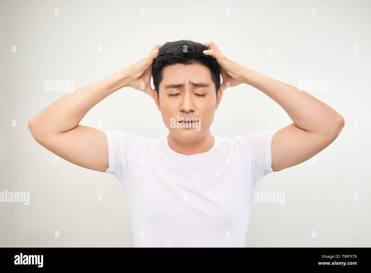 Asian man white shirt feel headache and touch at head by two hand in ...