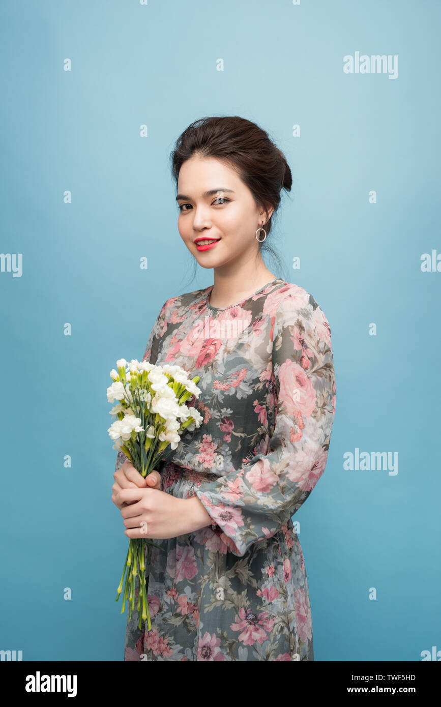 Interested young woman in cute dress in blue background Stock Photo - Alamy