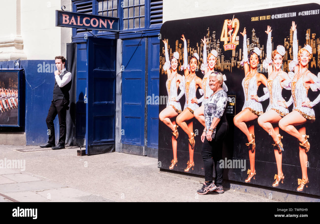Woman standing in front of poster with female tap dancers advertising ...