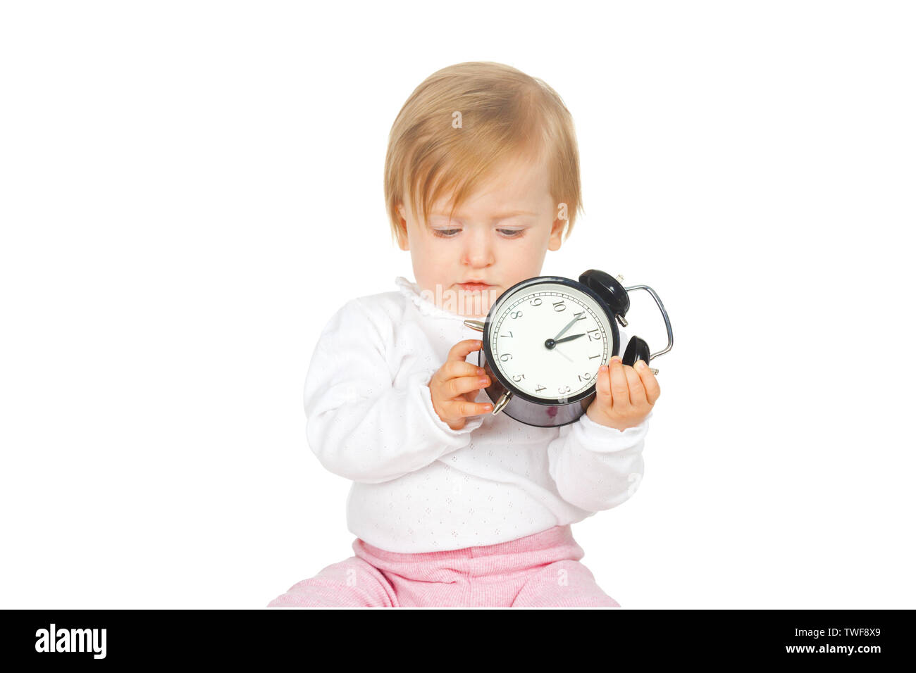 Caucasian girl baby with black alarm clock isolated on white background ...