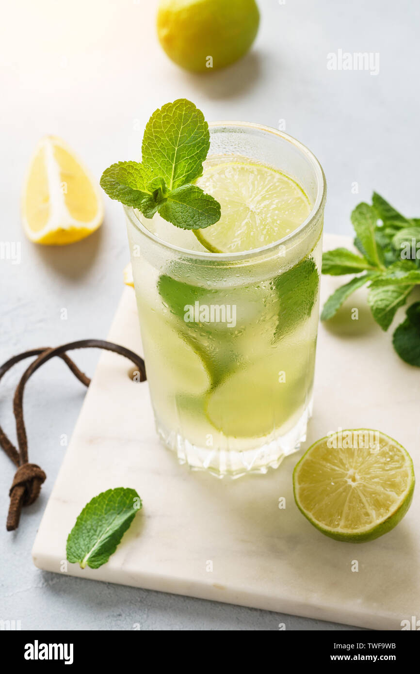 Cold lemonade with fresh lemon, lime and mint in a glass. Refreshing ...