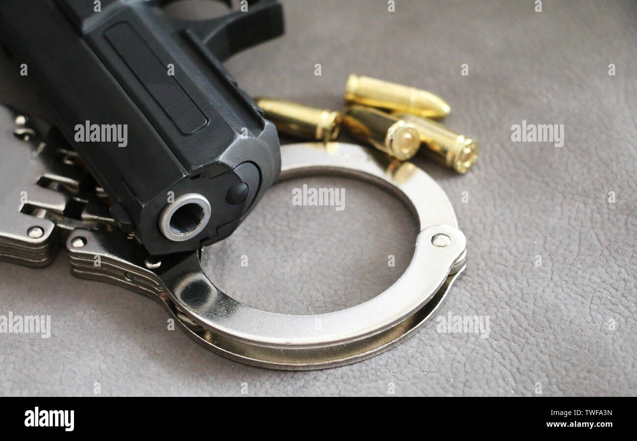 Gun handcuffs and pistol bullets Stock Photo - Alamy