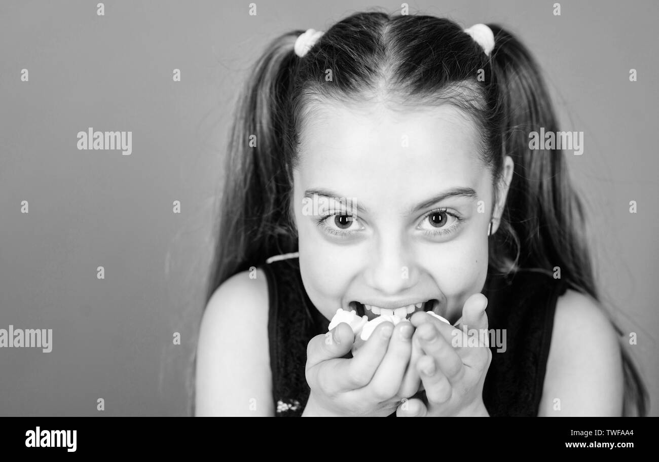 Incorrigible sweet tooth. Girl smiling face holds sweet marshmallows in ...