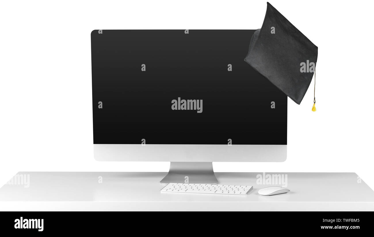 Computer monitor on white table with graduation cap isolated on white ...