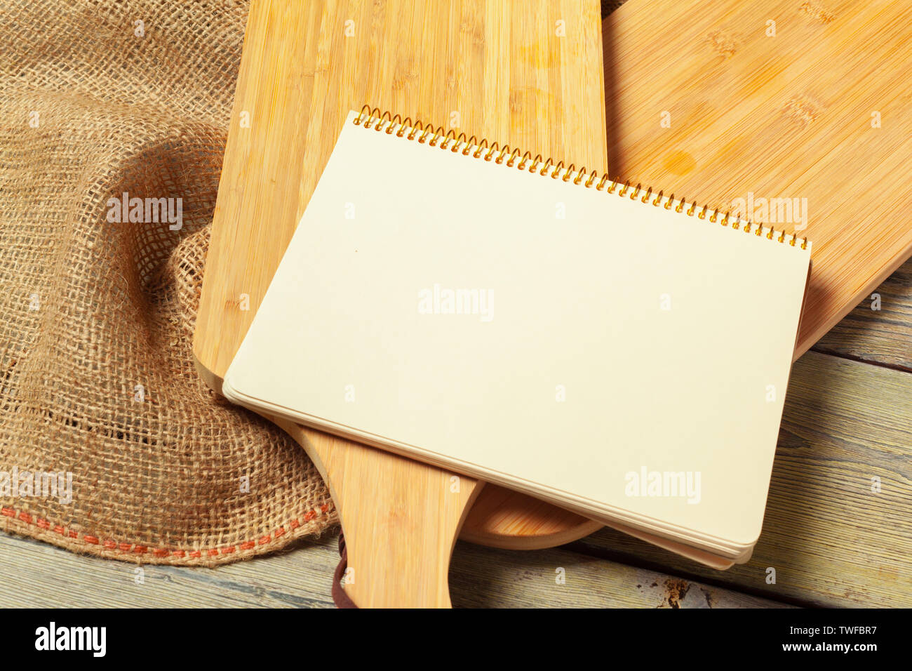 Blank sheet of opened notepad and kitchen utensils on table with ...