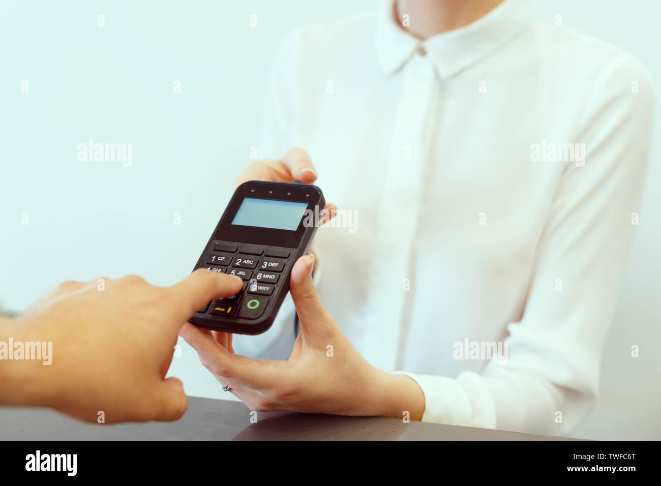 Guest at hotel reception paying with check during check-in Stock Photo ...