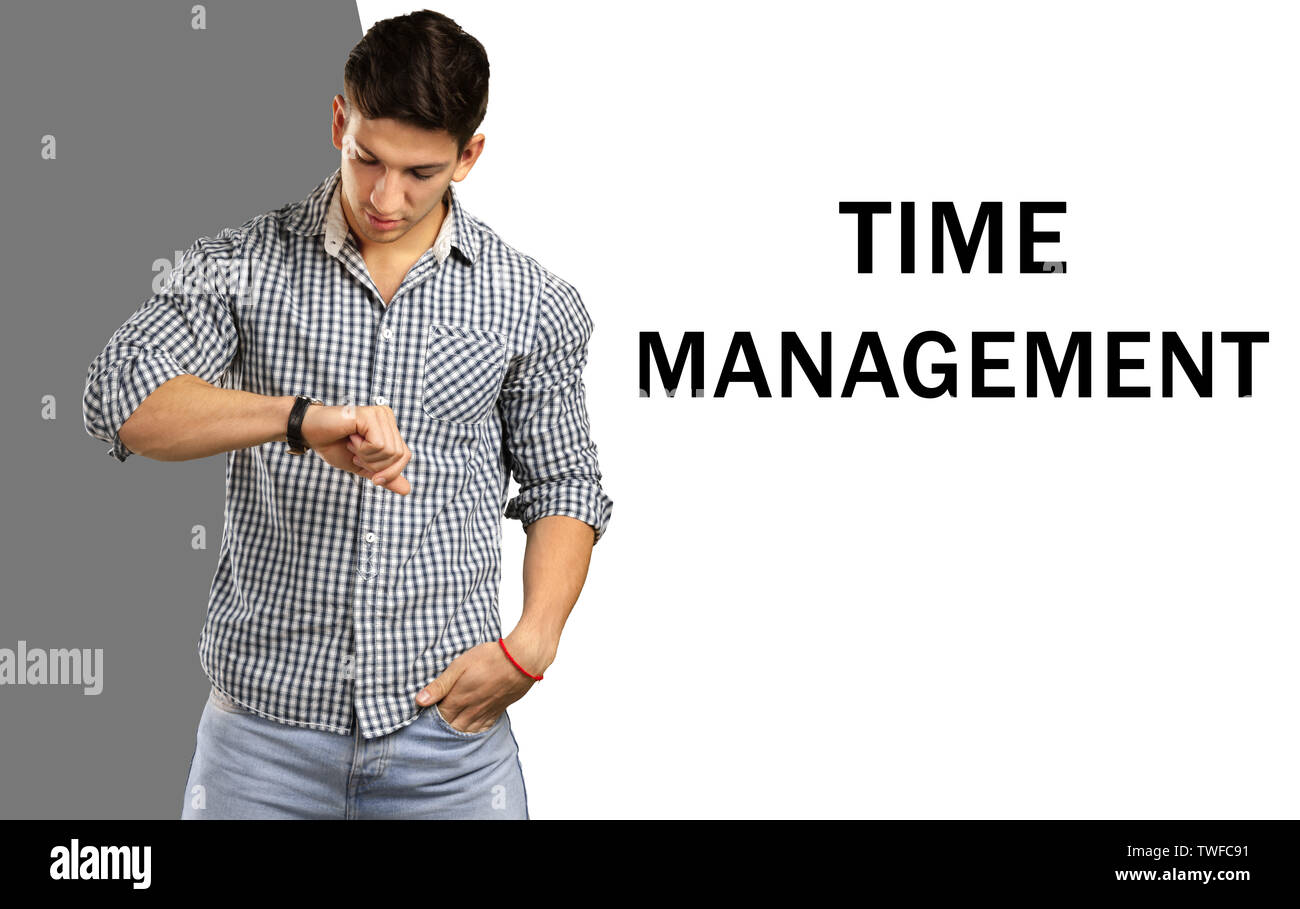 Young man looking at his watch, time management concept Stock Photo - Alamy