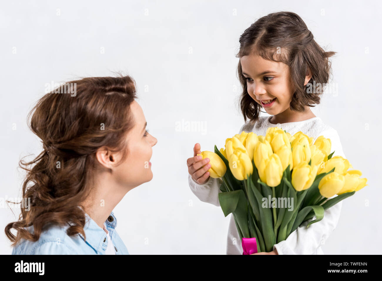Smiling kid presenting flowers mother hi-res stock photography and ...