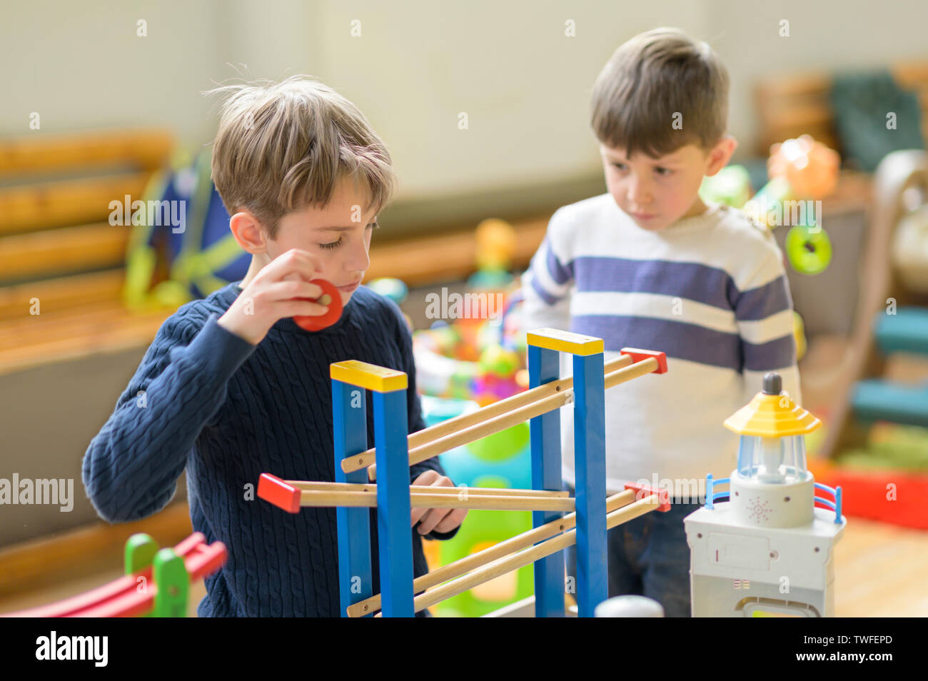 Cute little boys playing at kindergarten with slide wheels toy Stock ...