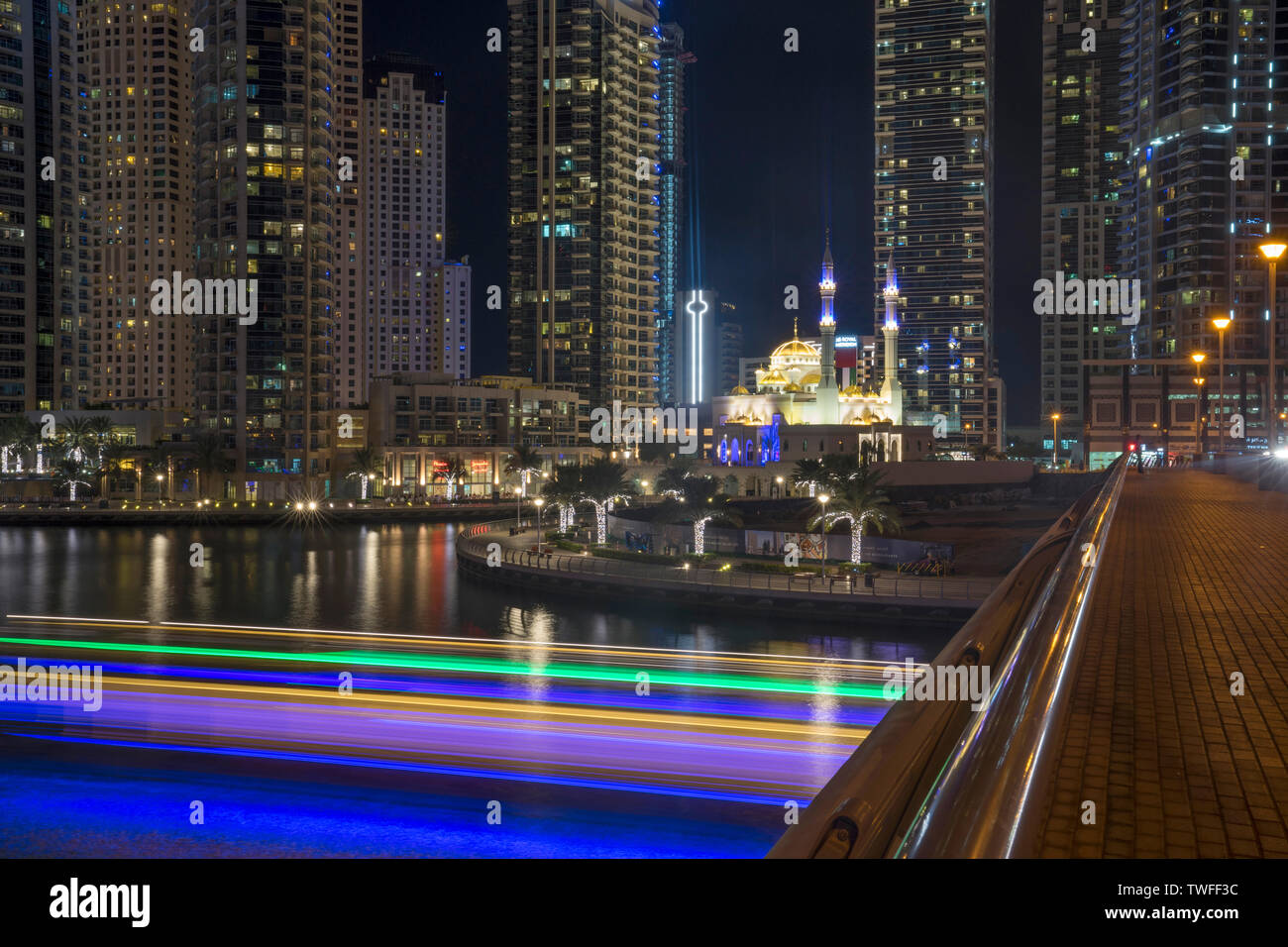 A dhow dinner cruise leaves trails of colourful light beneath an iconic ...