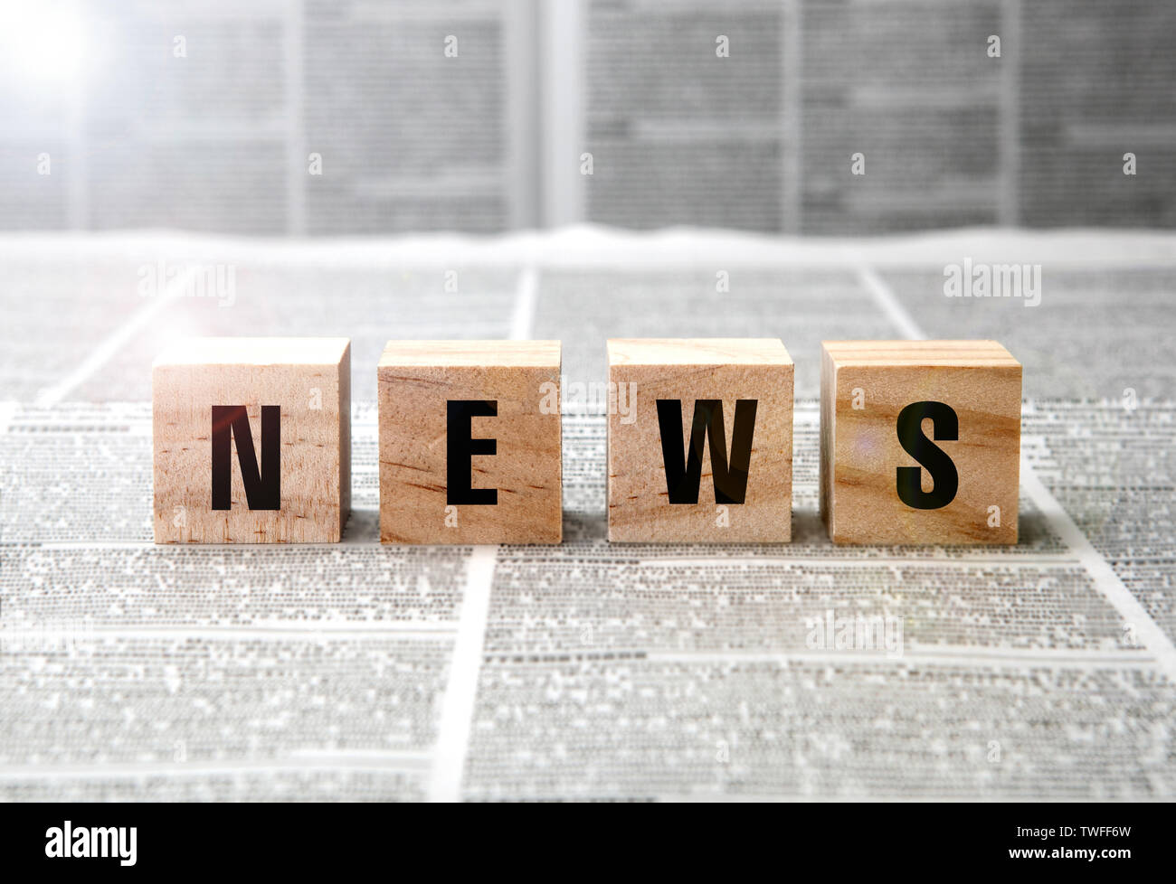 News title on square wooden blocks on a newspaper background closeup ...