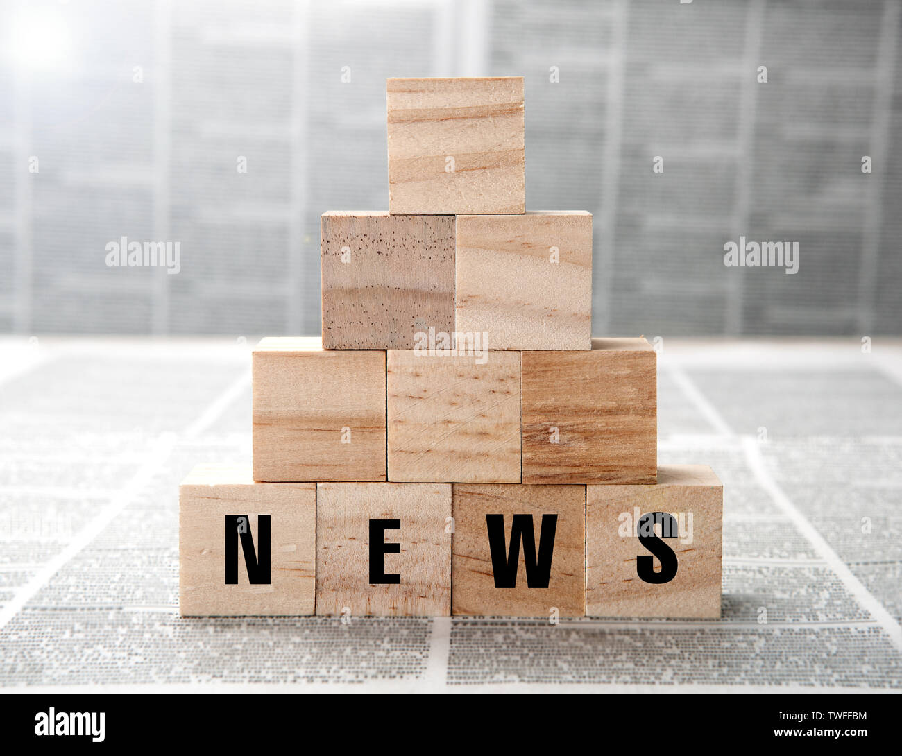 News title on square wooden blocks in the shape of a pyramid on a ...