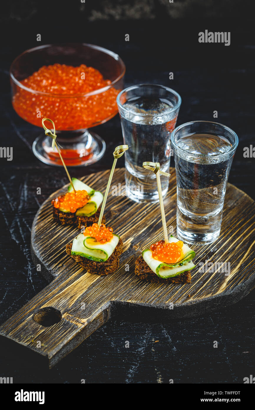 Delicious canapes with red caviar and two shots of vodka Stock Photo ...