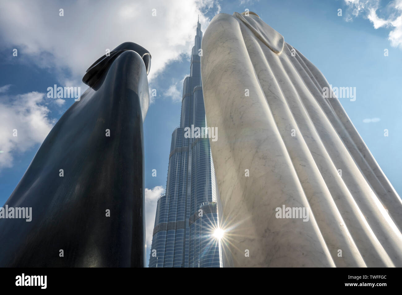 The graceful statues of an Arabic couple frame the Burj Khalifa in ...