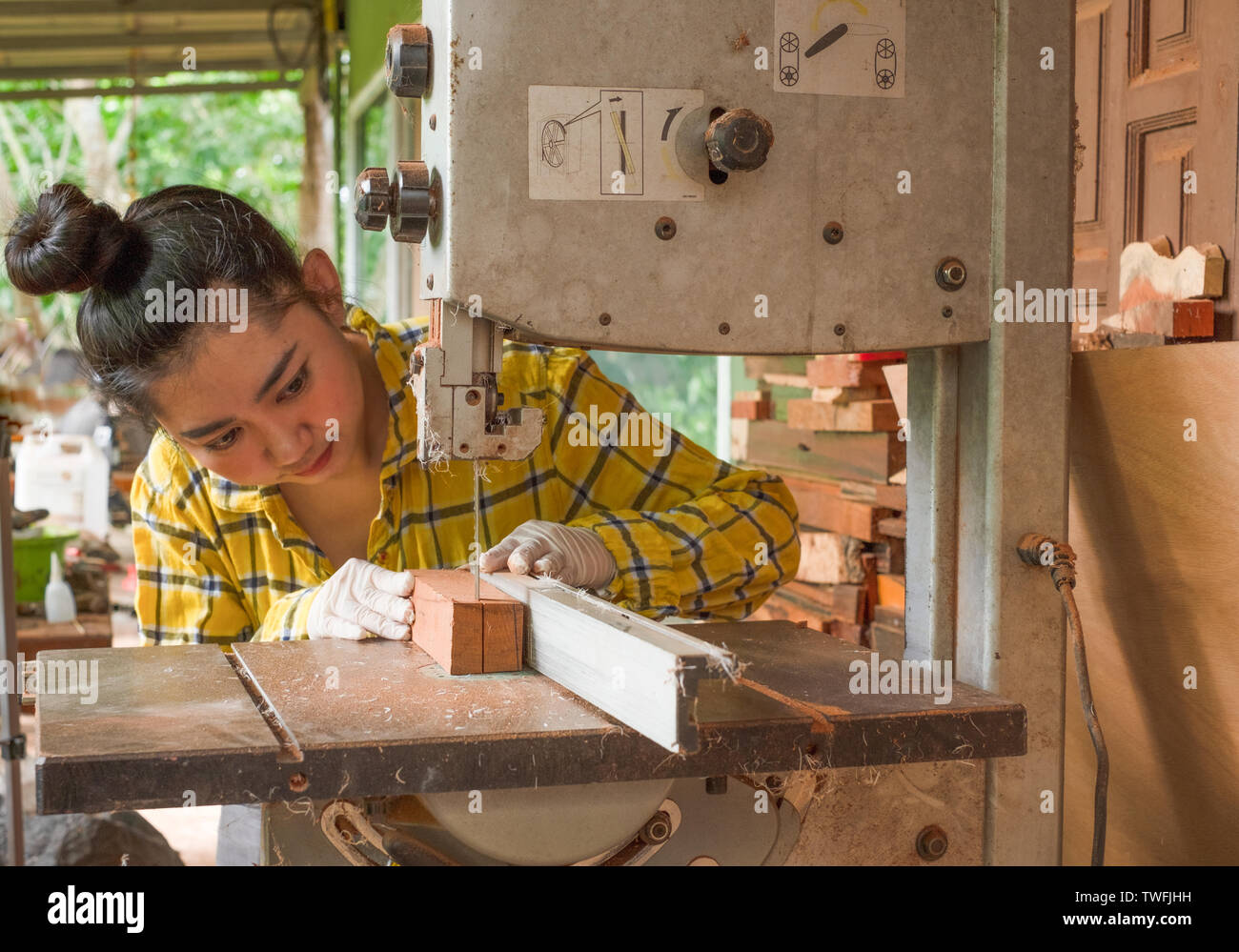 Women standing is craft working cut wood at a work bench with band saws ...