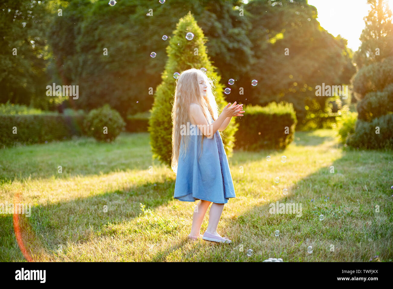 Child whirling, dancing plays on the meadow. Girl having fun with ...