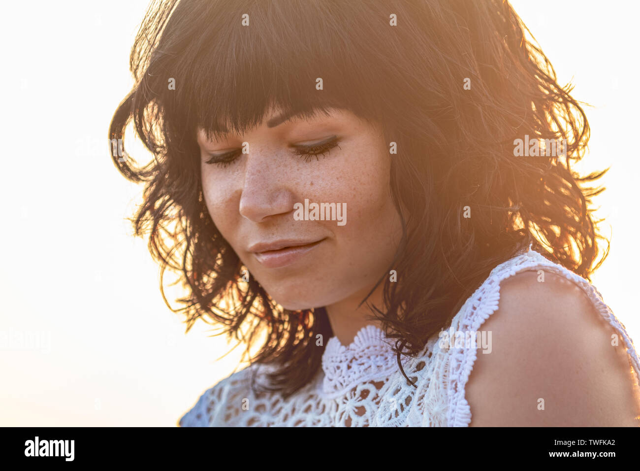 Cute happy beautiful woman female against a background of the sunset ...