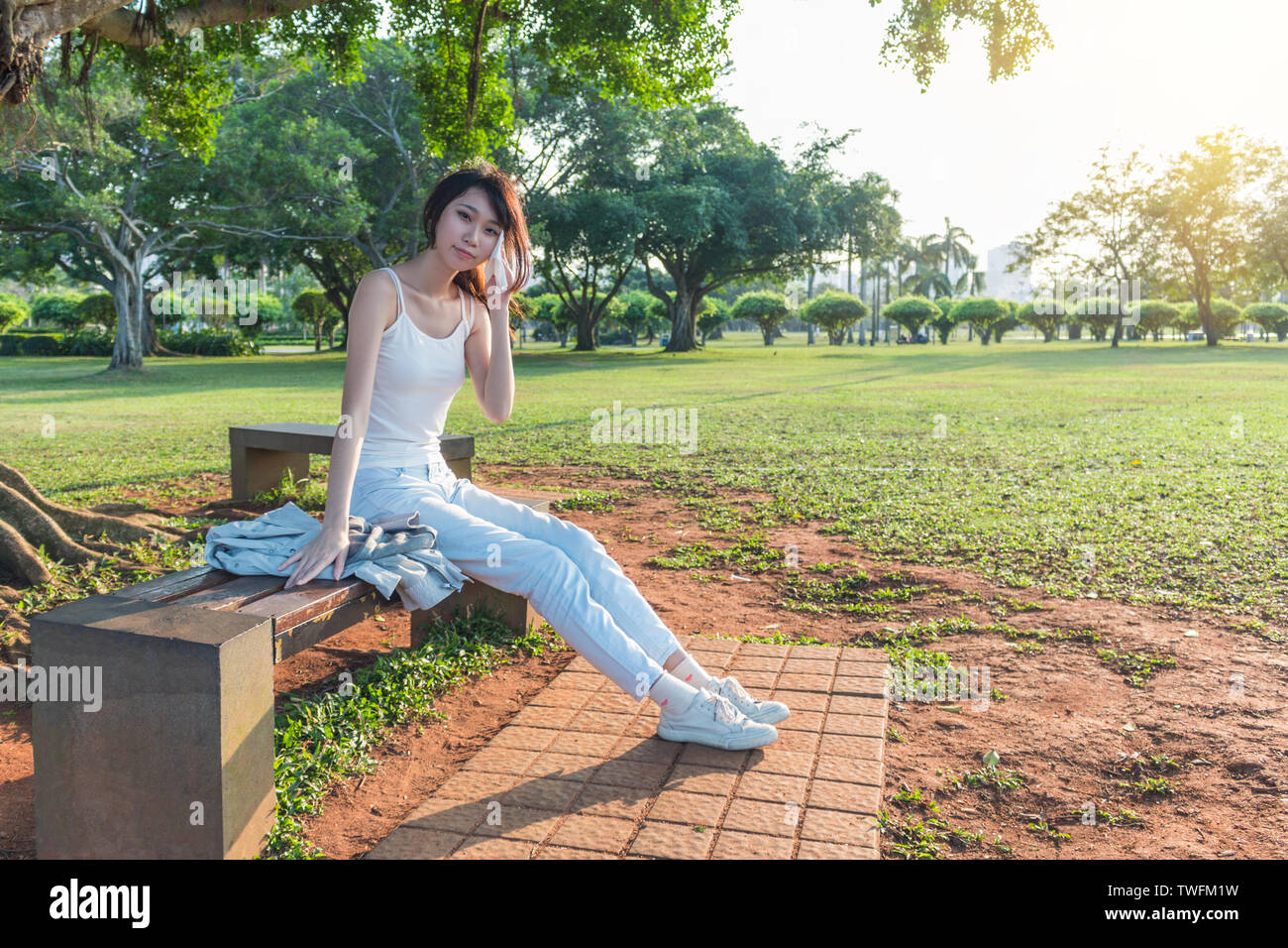 A girl sweating on a park bench Stock Photo - Alamy