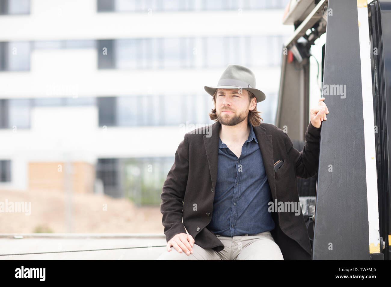 Portrait of a man sitting on the back of a truck Stock Photo - Alamy