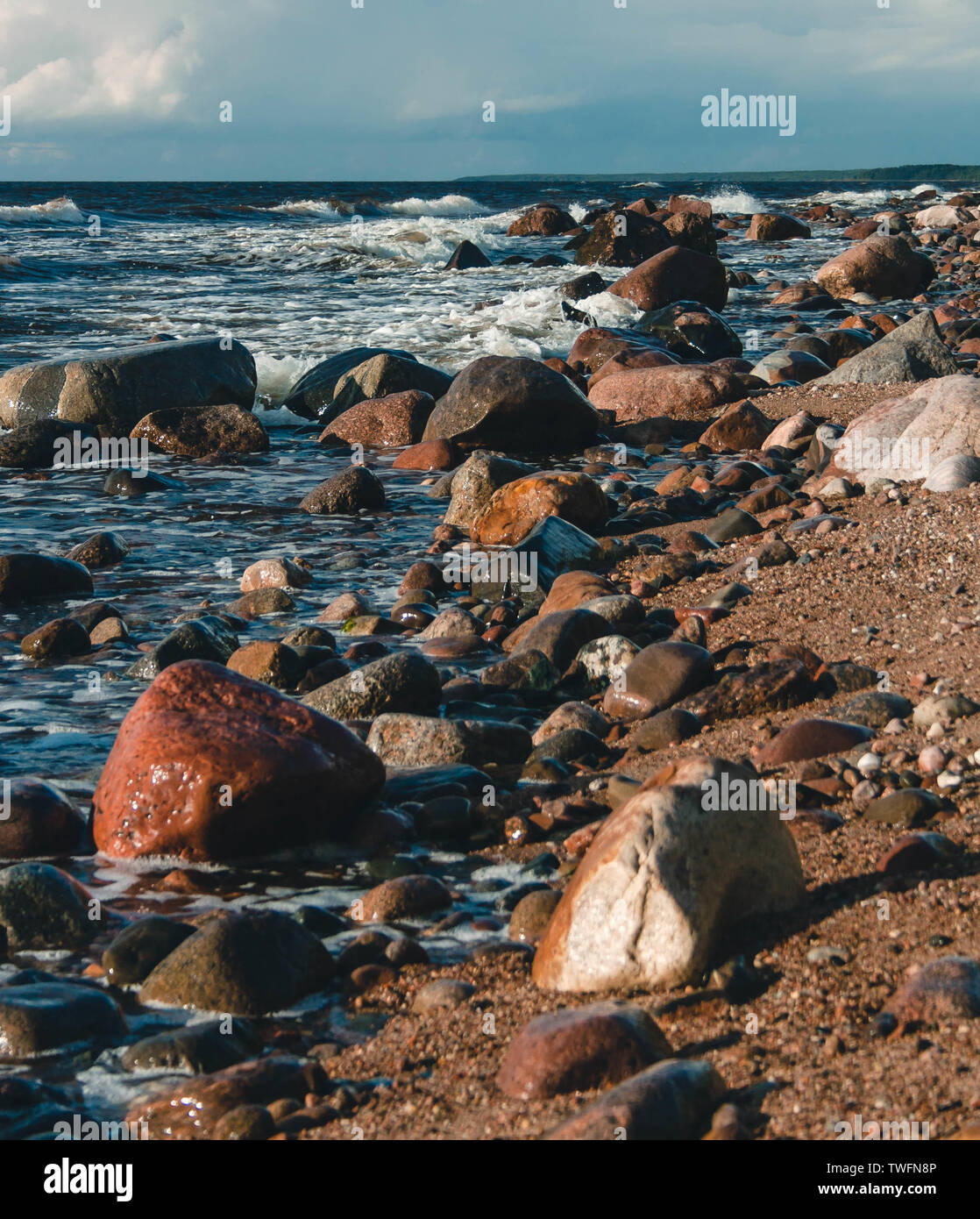 Stones in sea with waves splashing around them Stock Photo - Alamy