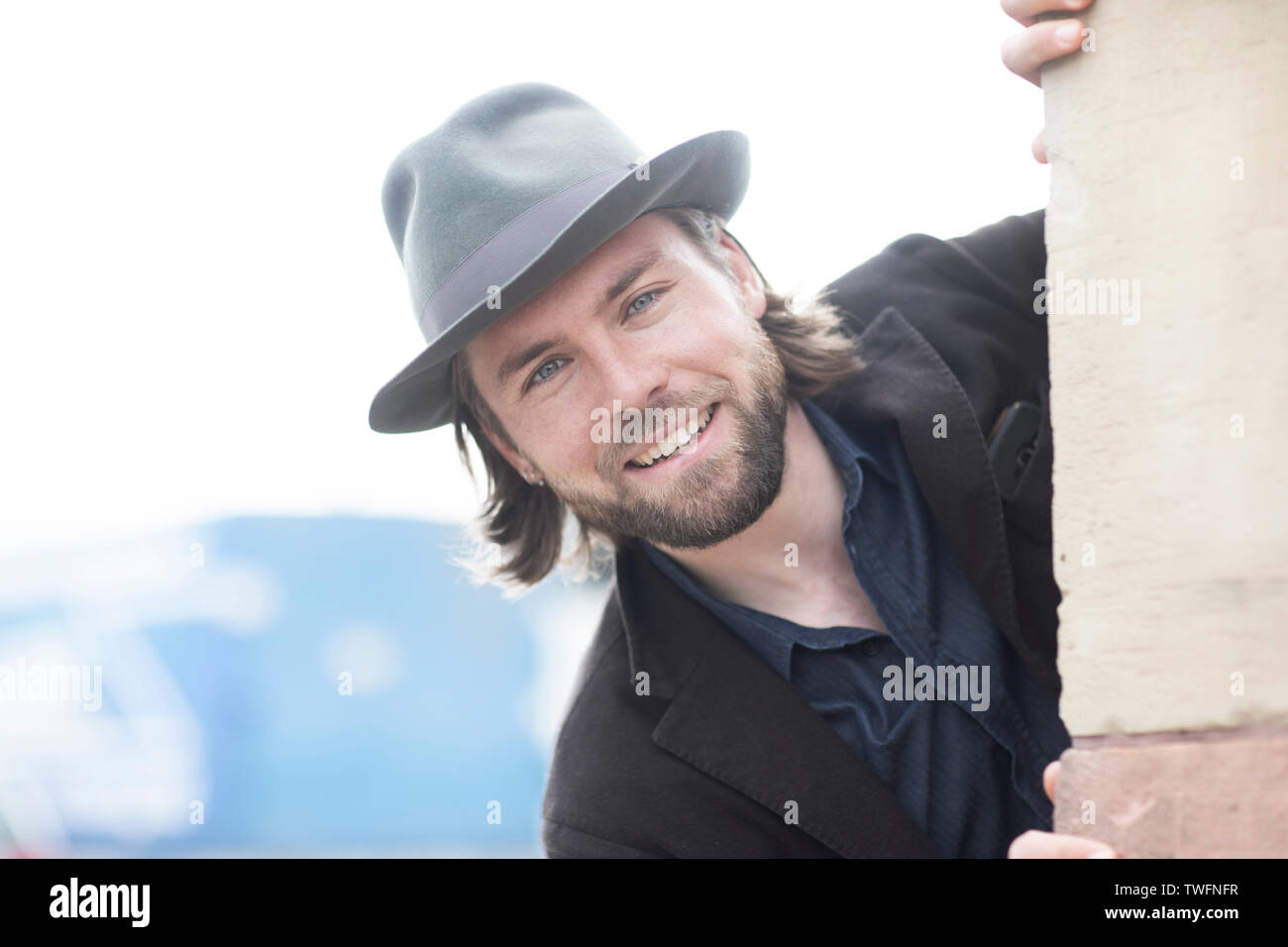 Portrait of a man looking round the corner of a building Stock Photo ...