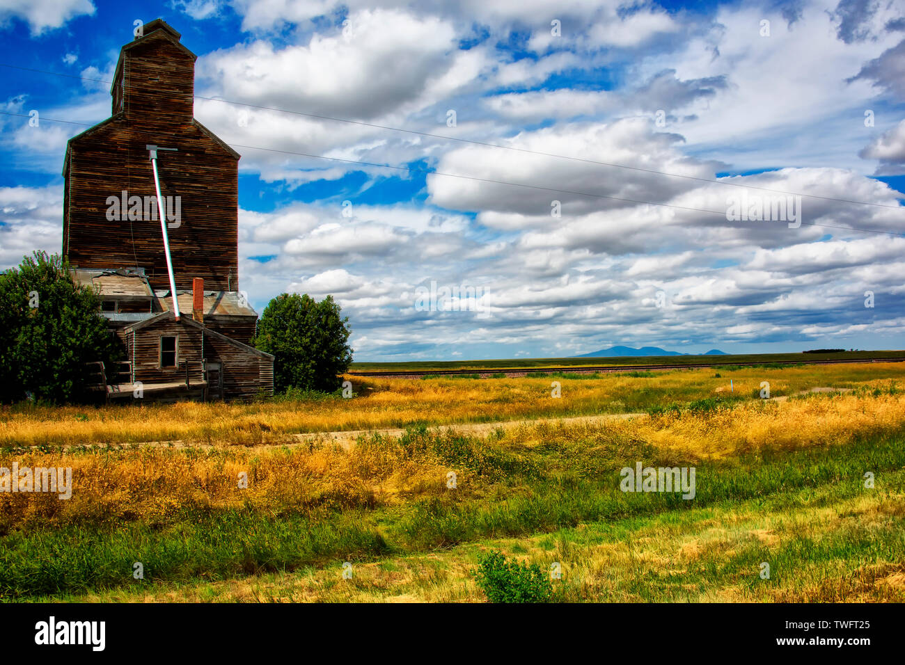 Old grain elevator on prairies with train tracks and blue sky Stock ...