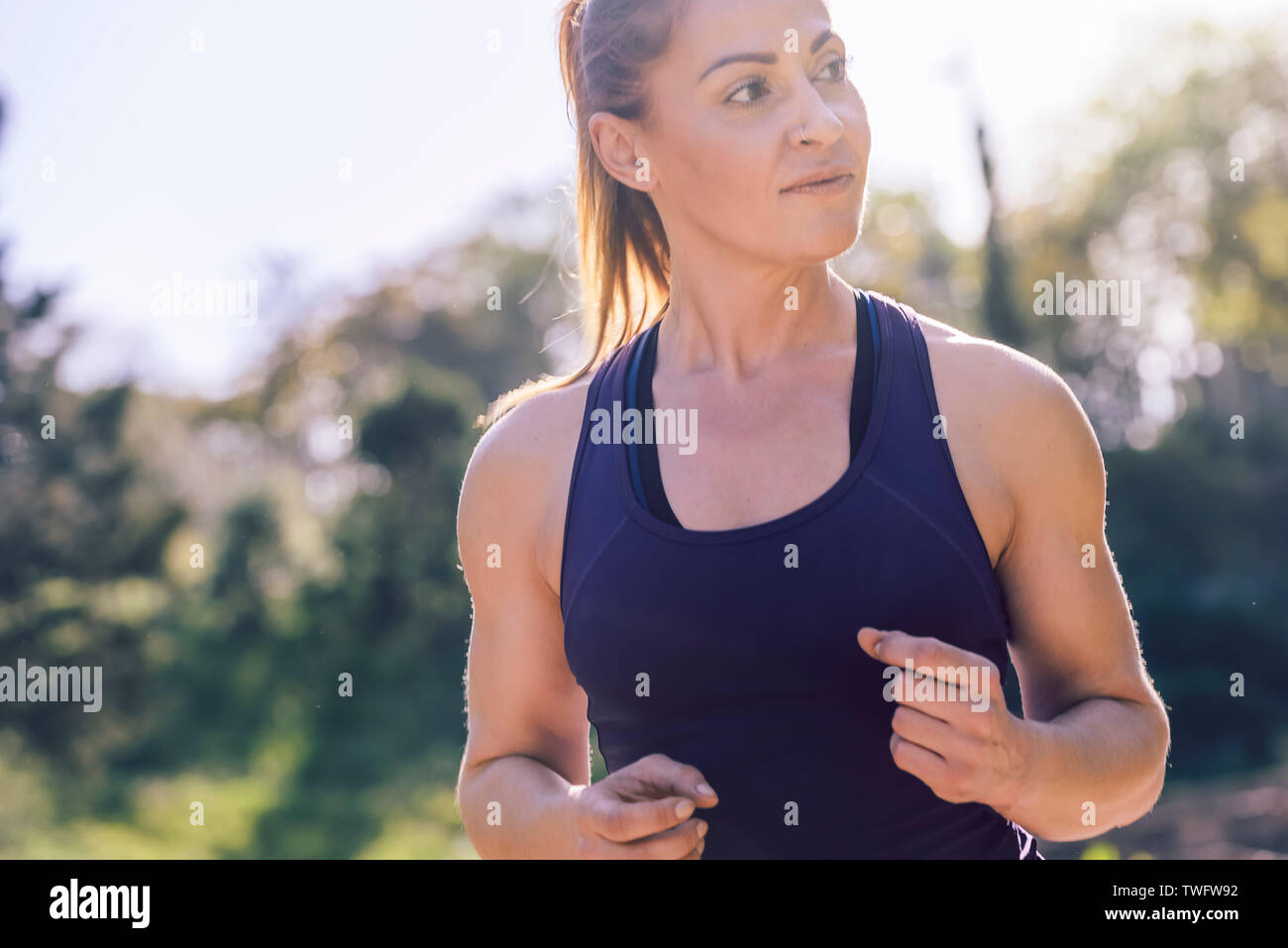 portrait of beautiful sports woman running during outdoor workout at ...