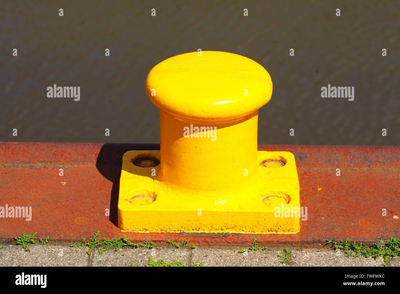 Yellow bollard, bollard in the harbor Stock Photo - Alamy