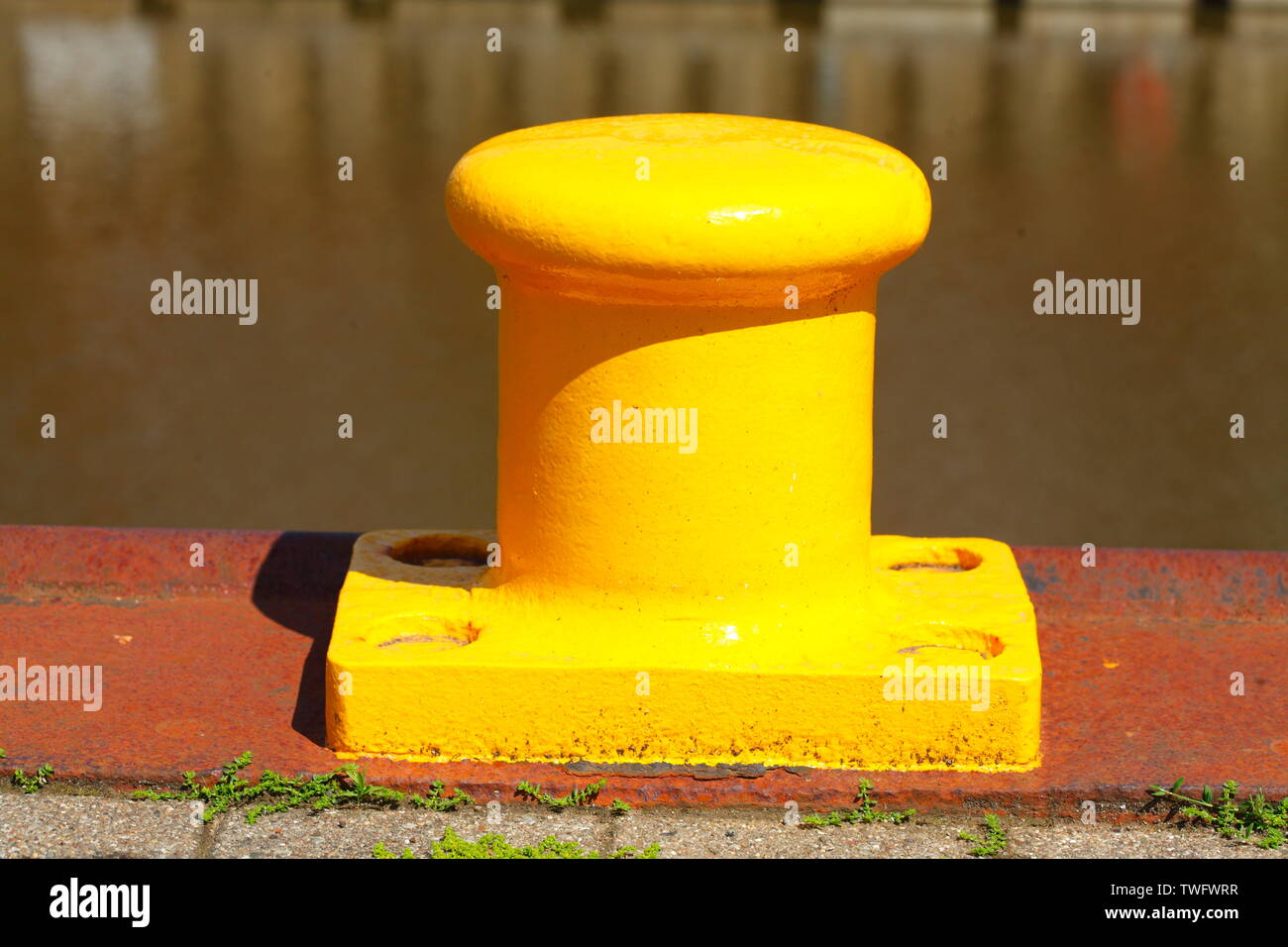 Yellow bollard, bollard in the harbor Stock Photo - Alamy