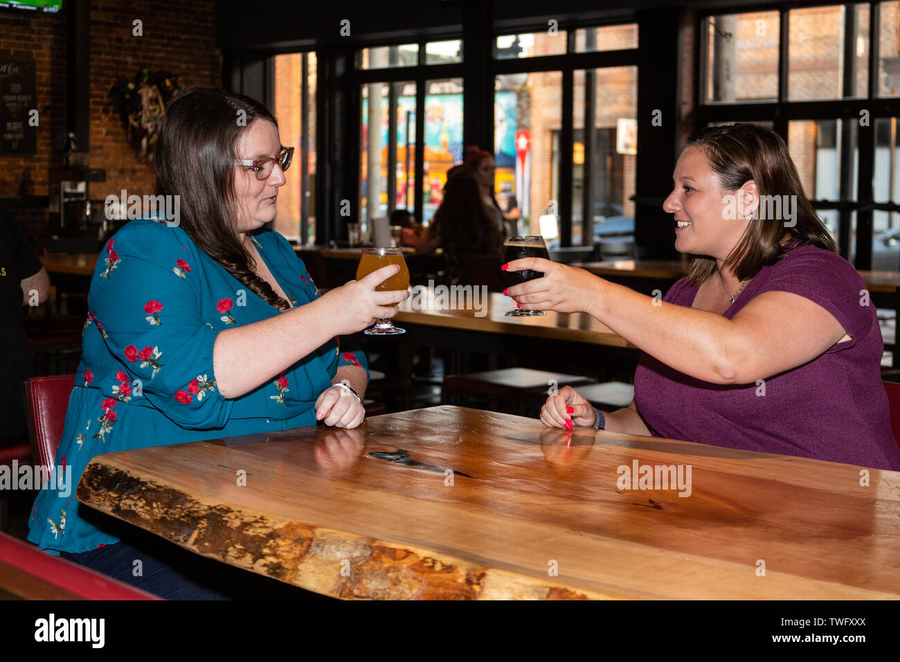 Two women together in a brewery having a beer Stock Photo - Alamy