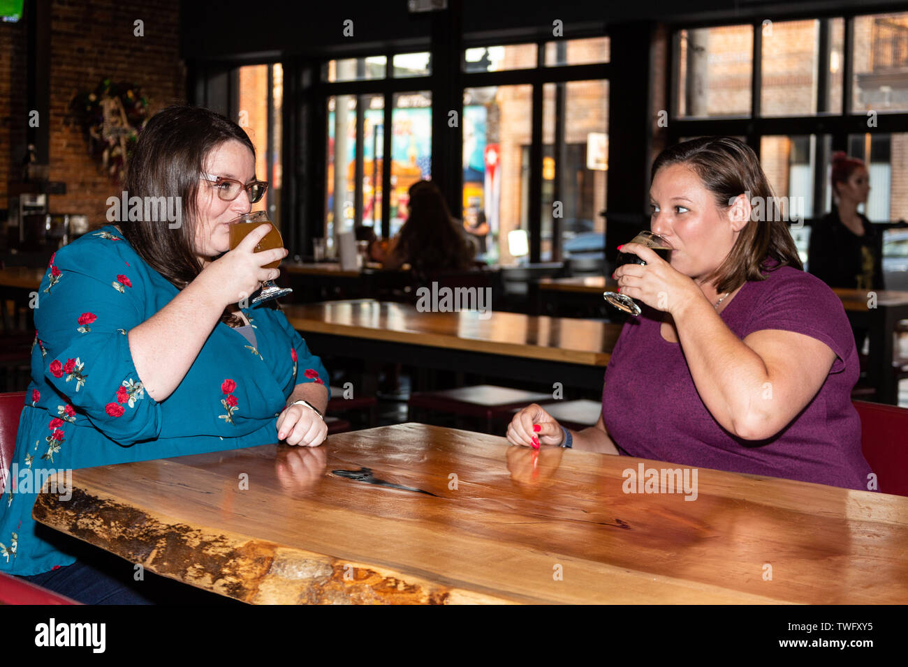 Two women together in a brewery having a beer Stock Photo - Alamy